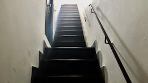 Uma escada com corrimão e uma porta no topo.
