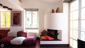 Uma sala de estar moderna com lareira, um conjunto de sofá e uma grande janela com persianas.