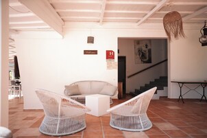 Decoração moderna com cadeiras de vime, um sofá, uma escada e uma placa com a palavra 'Welcome'.