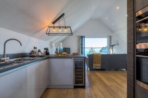 Um frigorífico, uma máquina de lavar louça, utensílios de cozinha