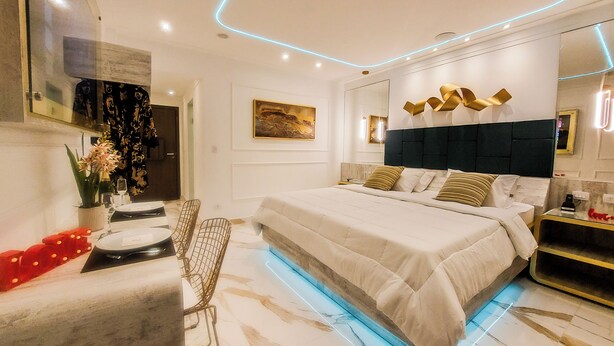 Quarto moderno com uma cama grande, uma escrivaninha e uma cadeira.