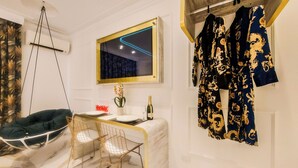 Quarto moderno com uma cadeira suspensa, uma mesa de jantar com cadeiras, um espelho e um roupão pendurado em um suporte.