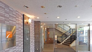 Entrada de hotel com a placa Chisun Inn, uma escadaria e piso de azulejos.