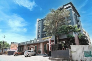 Um hotel com uma placa indicando 'Chaitanya Executive Lodging' e 'Hangout' no andar térreo.