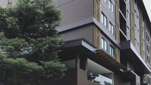 Um edifício moderno com telhado plano, janelas amplas e uma escadaria que leva a um andar superior.
