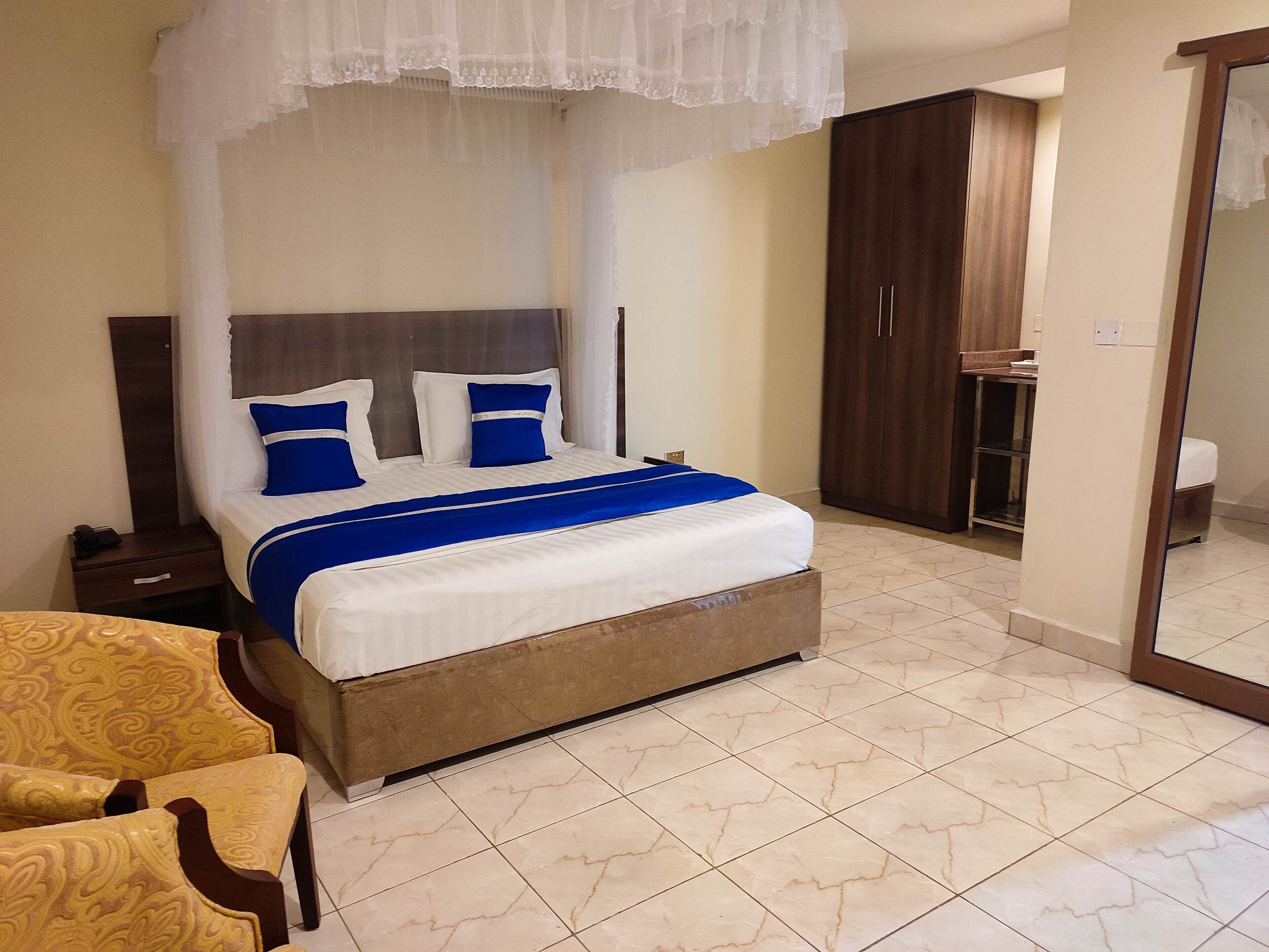Quarto com cama, guarda-roupa, mesa de cabeceira e uma cadeira.
