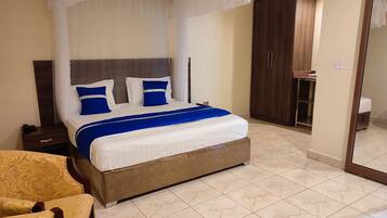 Quarto com cama, guarda-roupa, mesa de cabeceira e uma cadeira.
