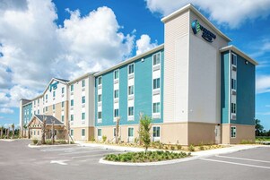 Um hotel com design moderno, destacando uma paleta de cores azul e bege, vários andares e fachada bem conservada.