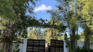 Uma entrada com portão e um caminho pavimentado que leva a um edifício.