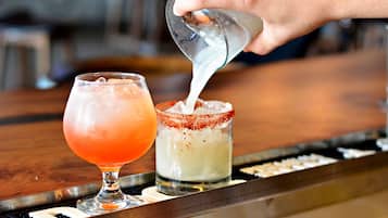 Um bartender servindo uma bebida em um copo.