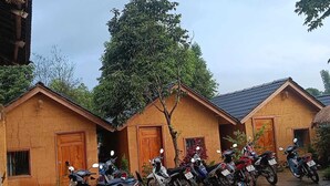 Fileira de edifícios de madeira tradicional com várias motocicletas estacionadas na frente.