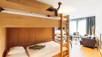 Uma cama beliche com escada, uma mesinha e um sofá numa sala de estar moderna.
