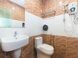 Casa de banho com lavatório, sanita e chuveiro.