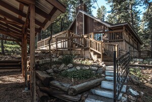 Uma cabana de madeira com uma escadaria de madeira que dá para um deck.