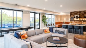 Uma sala de estar moderna com sofá, mesa de centro e área de jantar com balcão.