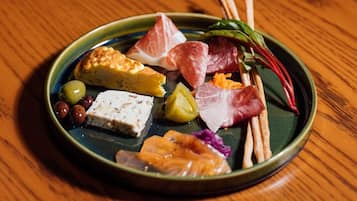 Um prato com diversos alimentos, incluindo queijo, azeitonas e legumes.