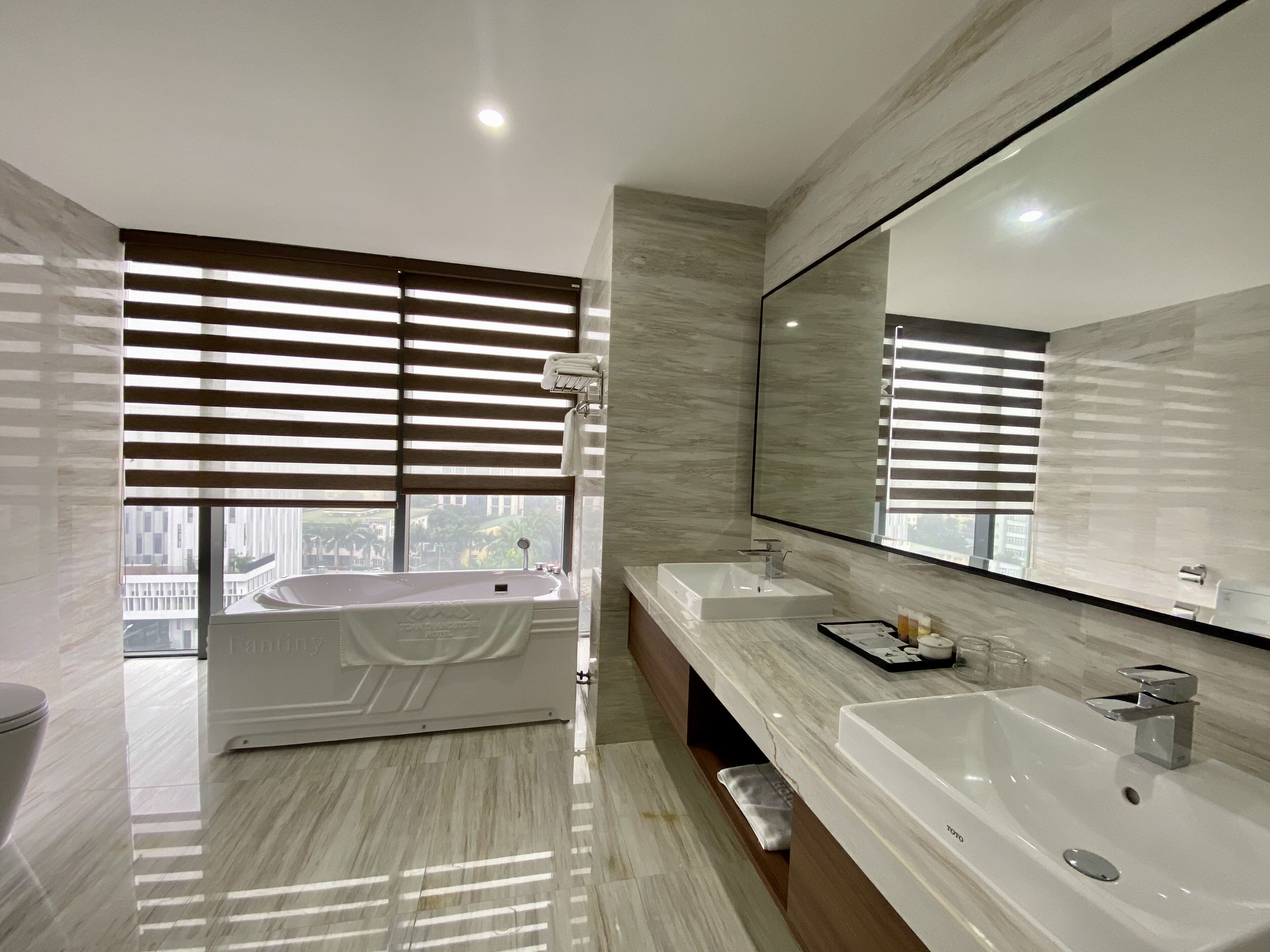 Uma casa de banho moderna com uma banheira grande, duas pias e um espelho amplo.