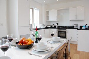 Um frigorífico, uma máquina de lavar louça, utensílios de cozinha 