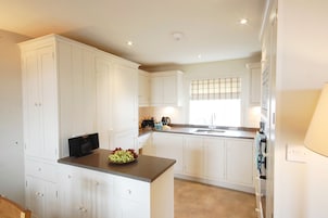 Um frigorífico, uma máquina de lavar louça, utensílios de cozinha