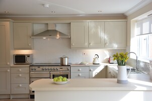 Um frigorífico, uma máquina de lavar louça, utensílios de cozinha 