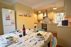 Um frigorífico, uma máquina de lavar louça, utensílios de cozinha