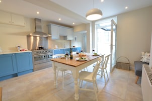 Um frigorífico, uma máquina de lavar louça, utensílios de cozinha