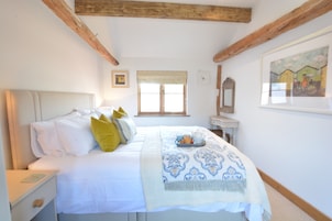 Quarto com cama, mesa de cabeceira e janela.