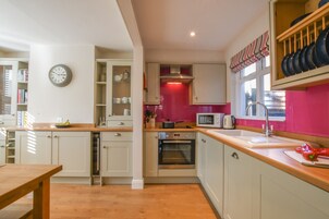 Um frigorífico, uma máquina de lavar louça, utensílios de cozinha 