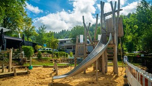 Uma área de recreação infantil com escorrega e estruturas para escalar.