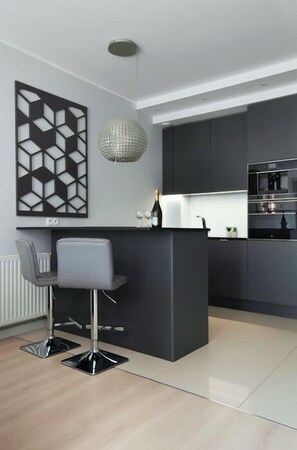 Apartamento Deluxe | Cozinha privada | Um frigorífico/congelador grande, um forno, uma placa de cozinha 