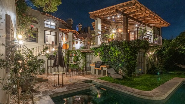 Uma vila luxuosa com piscina, área de estar ao ar livre e um alpendre bem iluminado.