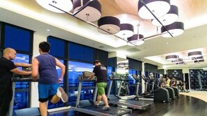 Uma academia com esteiras, bicicletas ergométricas e aparelhos de musculação.