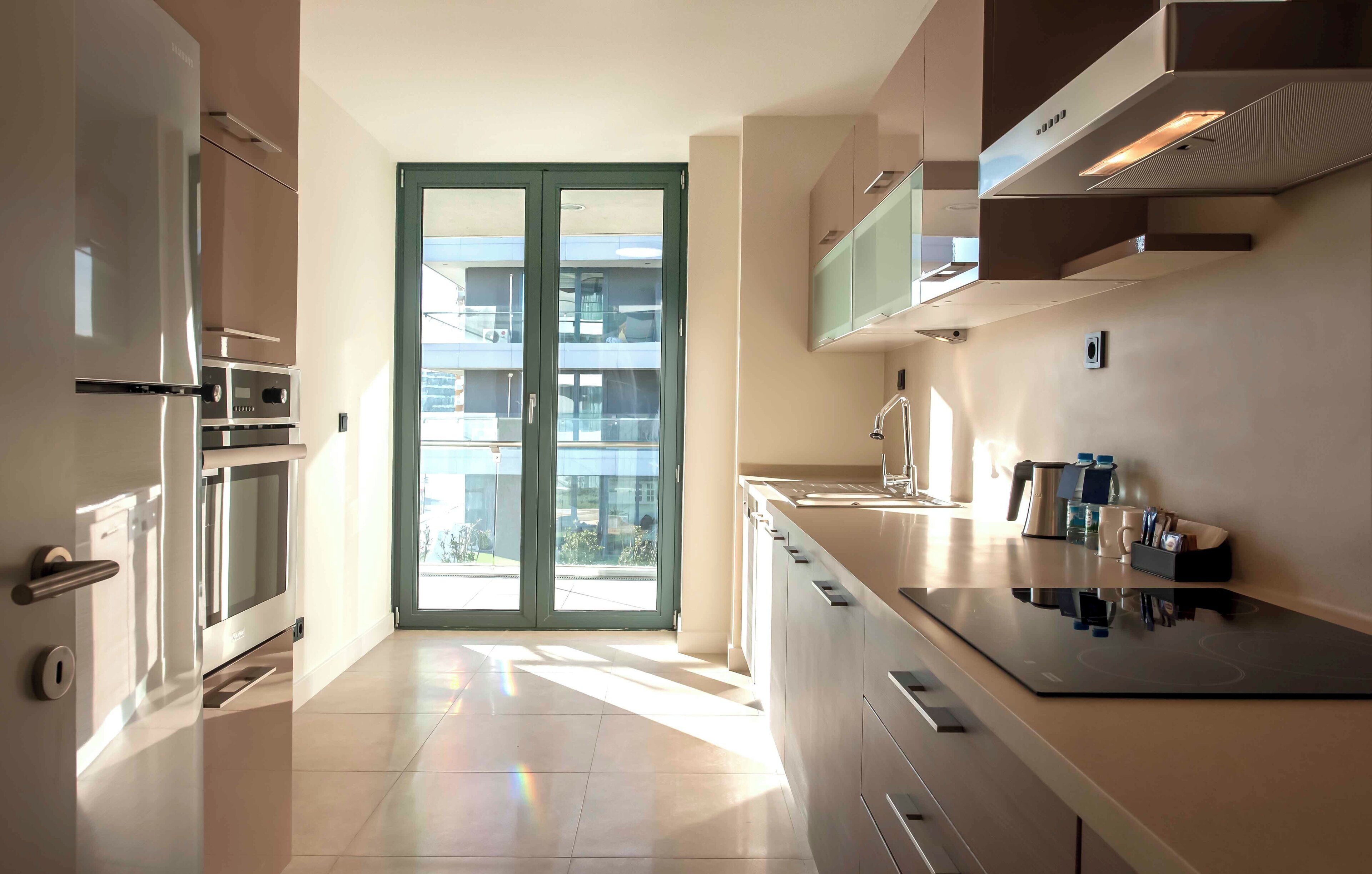 Uma cozinha moderna com uma janela grande, eletrodomésticos embutidos e uma bancada elegante.