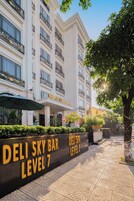 Entrada de um hotel com uma placa indicando 'DELICACY HOTEL & SPA' e 'DELI SKY BAR ANDAR 7'.