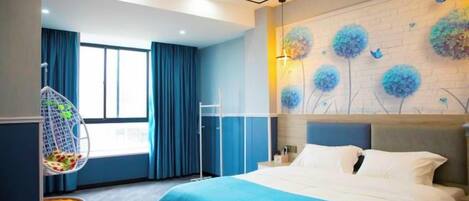 Quarto de hotel moderno com uma cama grande, uma cadeira suspensa e uma parede com um mural floral.