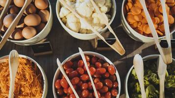 Diversos alimentos em recipientes com utensílios de madeira.