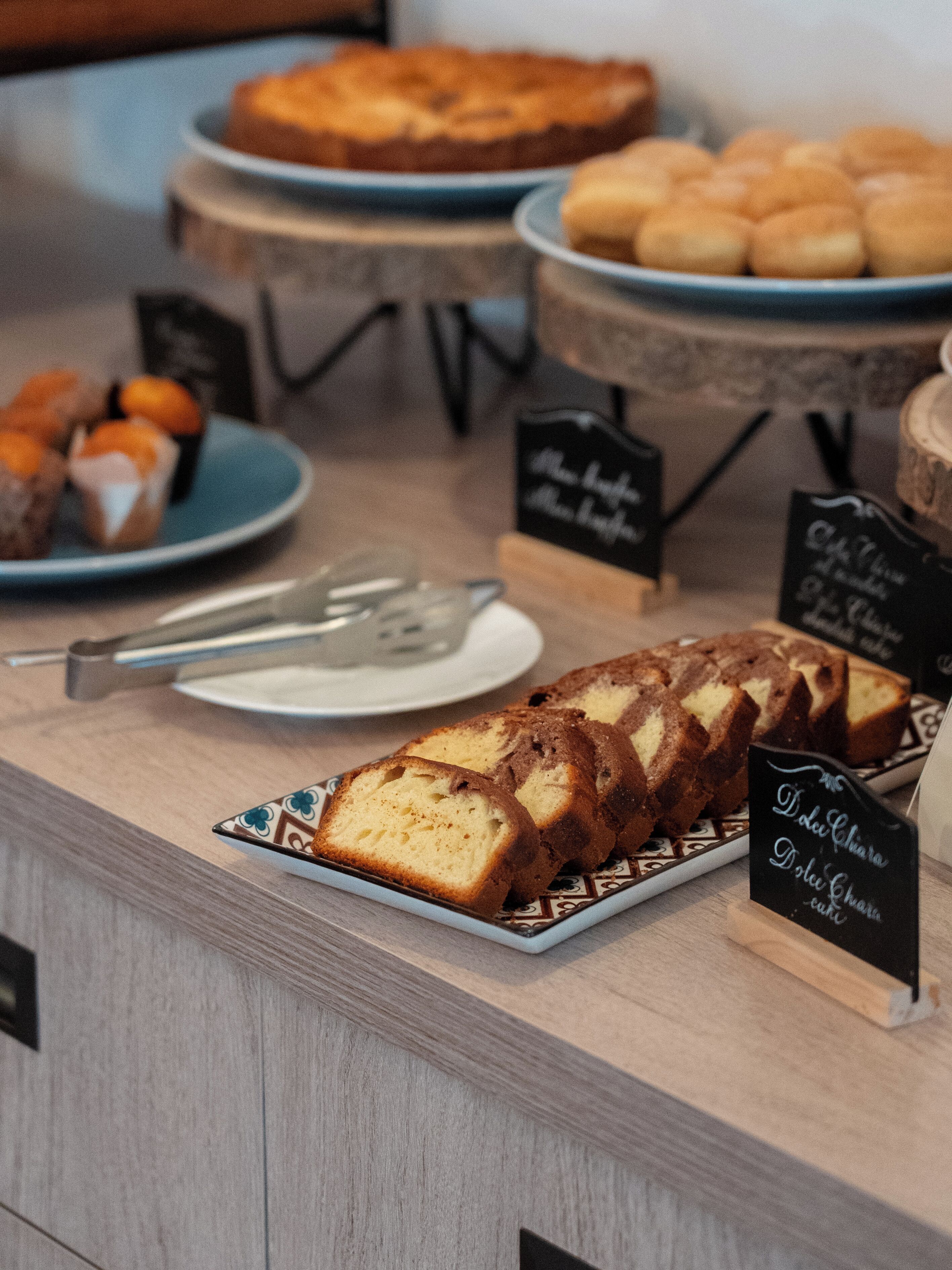 Vitrine de uma padaria com diversos produtos de panificação, incluindo pão e doces.