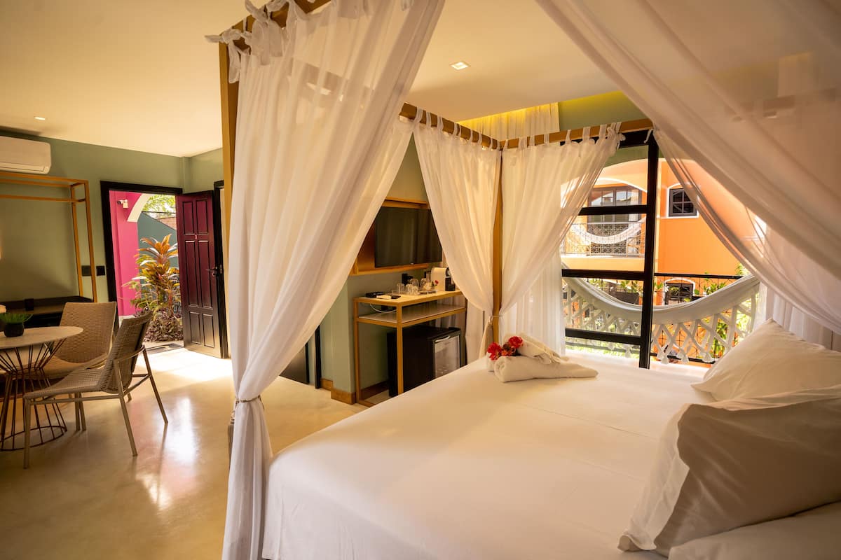 Quarto com cama, escrivaninha e cadeira.