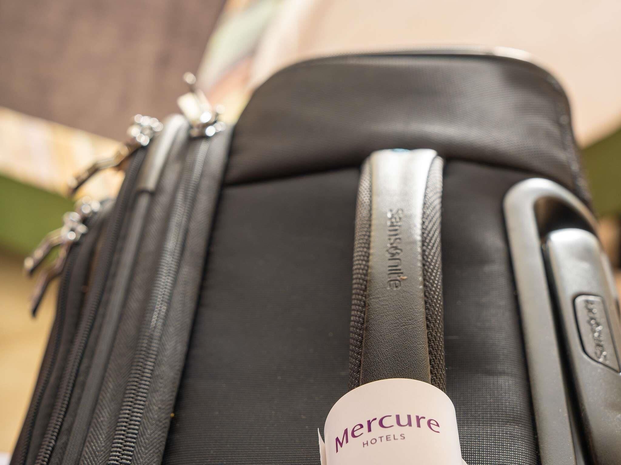 Uma mala preta com etiqueta de bagagem Mercure Hotels.