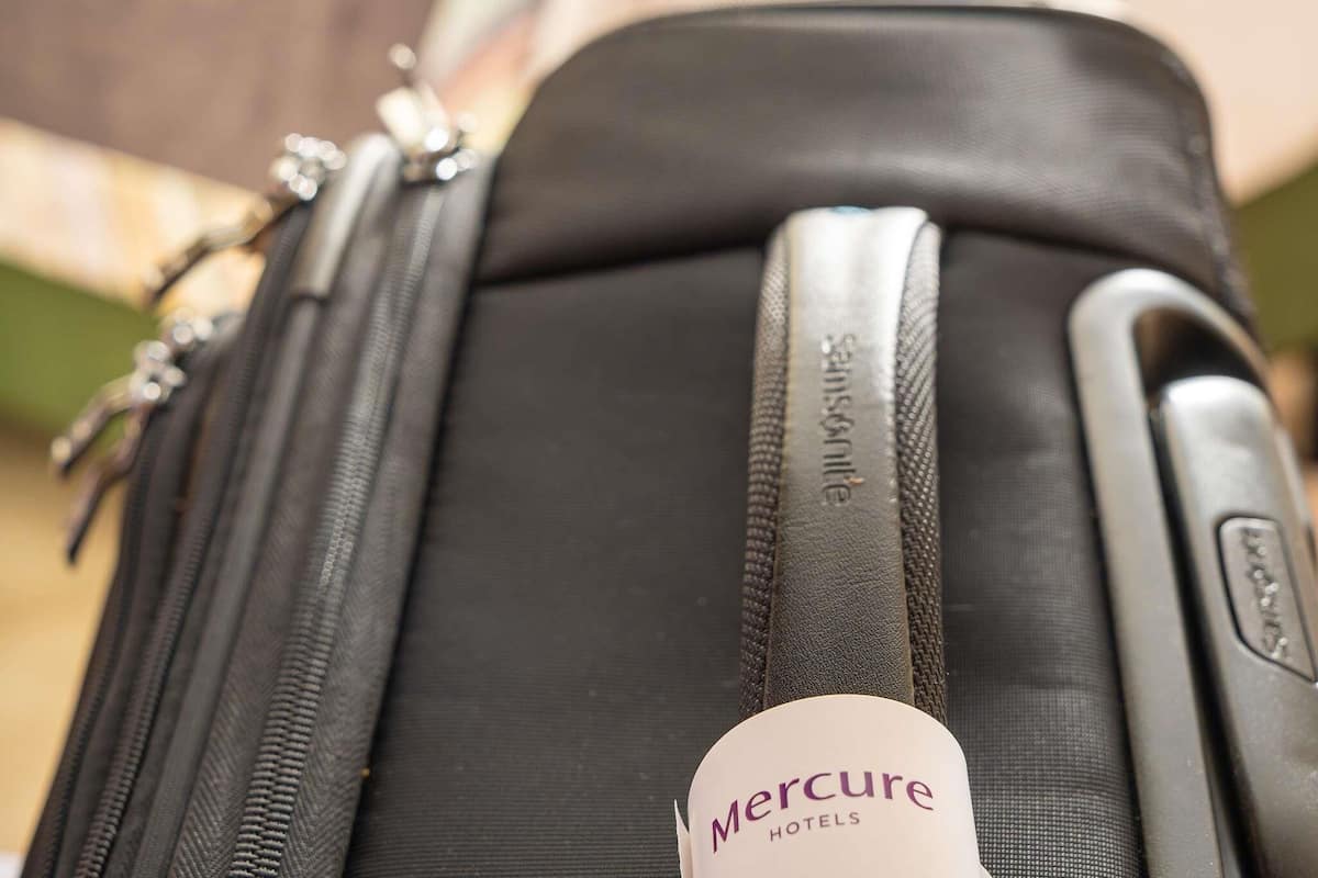 Uma mala preta com etiqueta de bagagem Mercure Hotels.