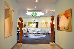 Um interior moderno com arte abstrata nas paredes, uma planta central e uma área de estar circular.