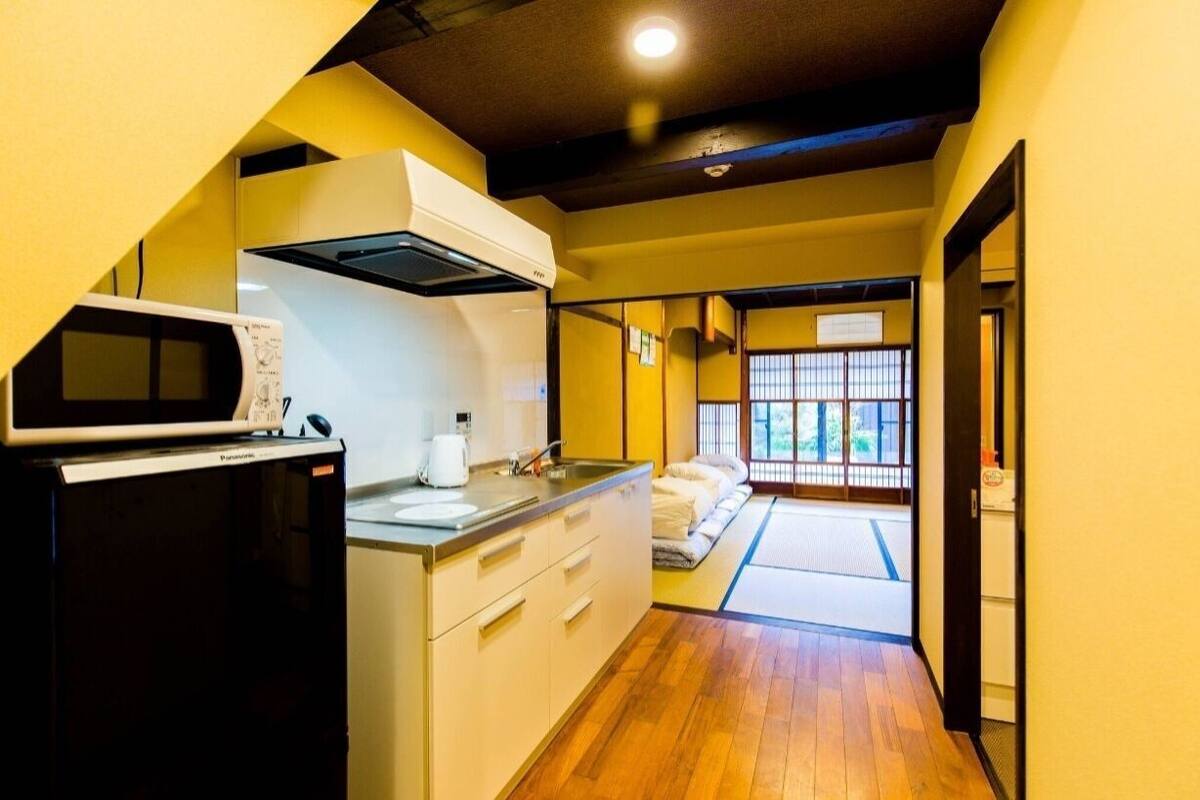 Cozinha compacta equipada com micro-ondas, fogão e pia.