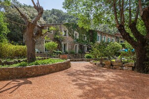 Um edifício rústico de pedra com um caminho de jardim que leva a uma área de estar.