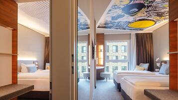 Quarto de hotel com uma cama, uma escrivaninha e vista para a cidade.