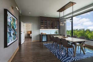 Uma cozinha moderna com armários escuros, uma ilha embutida e uma janela ampla com vista para o verde.
