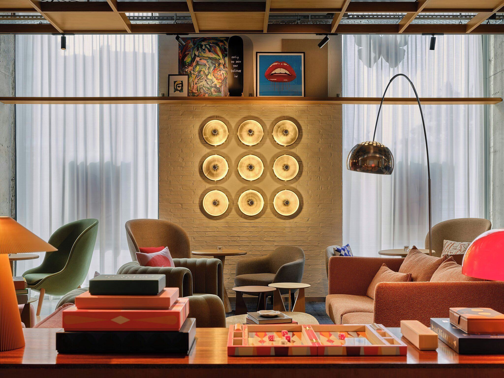 Uma sala de estar moderna com parede de tijolos, decorações redondas na parede e diversas opções de assento.