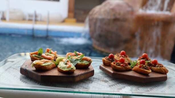Uma mesa de vidro com três tábuas de aperitivos.