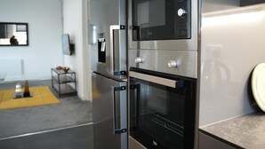 Uma cozinha moderna com eletrodomésticos de aço inoxidável, incluindo forno duplo e micro-ondas.