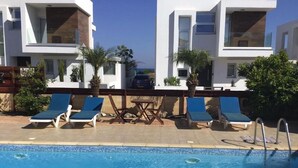 Uma área de piscina moderna com espreguiçadeiras e uma piscina.