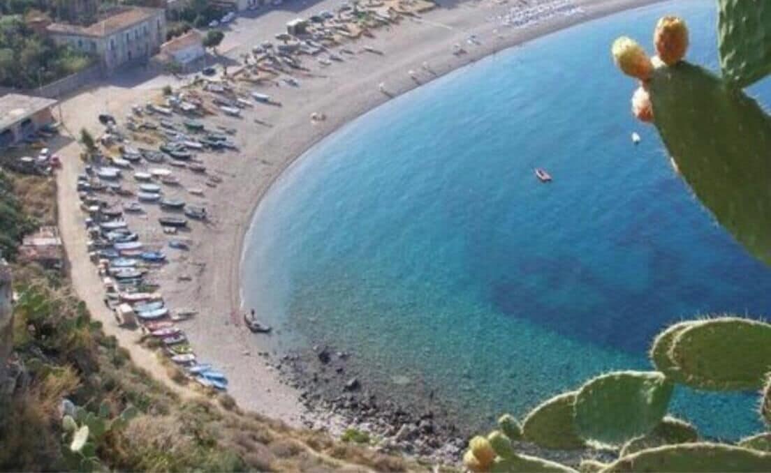 Uma área costeira com uma praia e barcos estacionados.